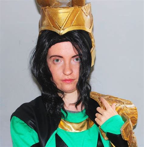 A Woman Wearing A Green And Gold Costume With A Golden Crown On Top Of