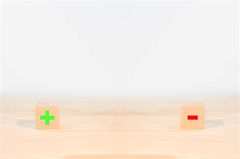 장점과 단점의 개념 비교 시트 에 대한 비교 시트 빨간색 마이너스와 흰색 배경에 녹색 플러스 두 나무 큐브 빼기 기호에 대한