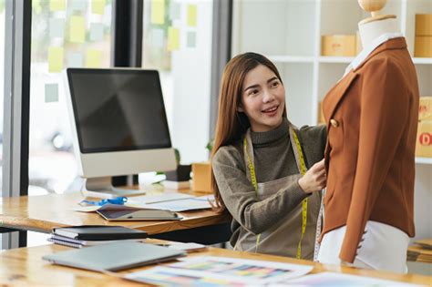 홈 오피스 워크샵에서 일하는 매력적인 아시아 여성 패션 디자이너 새로운 천 디자인 컬렉션을 만드는 세련된 패셔니 스타 여성 테일러와 바느질 사람들의 라이프 스타일과 직업