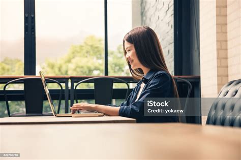 하늘과 나무 일상 생활 레트로 빈티지 컬러 톤에에서 현대 기술을 사용 하 여 젊고 현대적인 라이프 스타일 개념의 보기와 큰 창 근처 내부 그녀의 컴퓨터에서 작업 하는 캐주얼