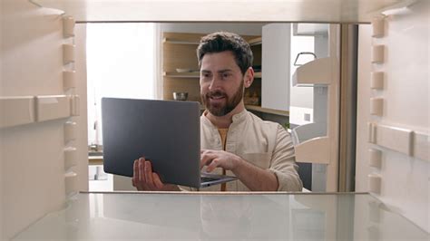 배고픈 남자 남자 빈 냉장고 혼란 찾기 문제 해결 아이디어 주문 음식 배달 노트북 온라인 구매 제품 컴퓨터 상점 앱으로 상품을 주문하는 관점 Pov 냉장고 내부에서 검색에