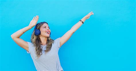 행복한 여자 헤드폰 파란색 배경에 오디오 미소 또는 모형 공간을 위해 스튜디오에서 음악에 맞춰 춤을 춥니다 Z세대 모델은 축하 파티 또는 자유의 에너지로 노래 소리 라디오를