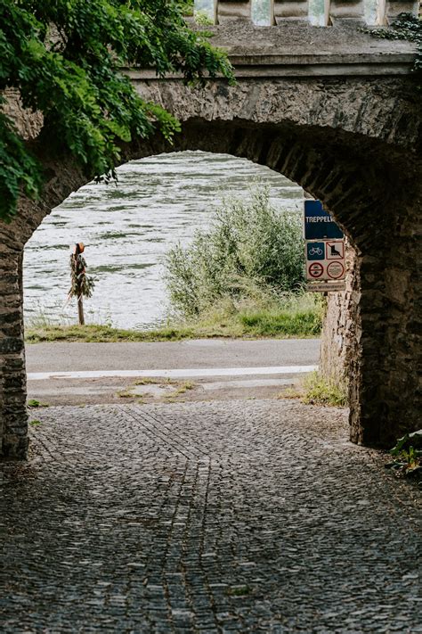강 옆 돌다리 아래에 서있는 사람 사진 Unsplash의 무료 오스트리아 이미지