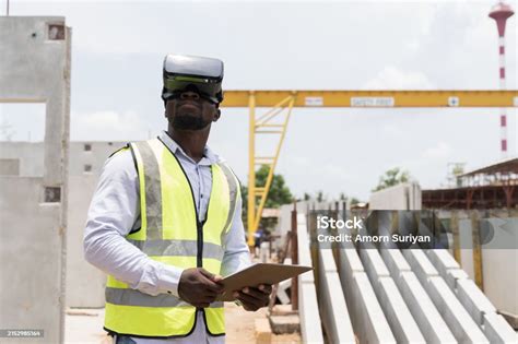 가상 현실 헤드셋을 착용한 아프리카계 미국인 남성 건설 엔지니어가 건설 현장에서 구조 품질을 검사하고 있습니다 현장 작업에서 Vr 헤드셋으로 작업하는 남성 건설 엔지니어