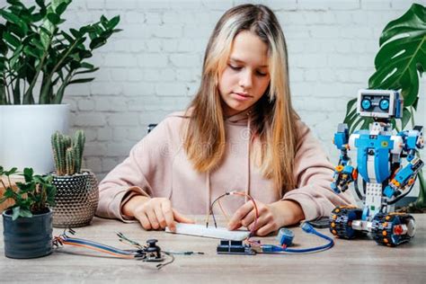 A Teenager Girl Plugging Cables To Sensor Chips While Learning Arduino