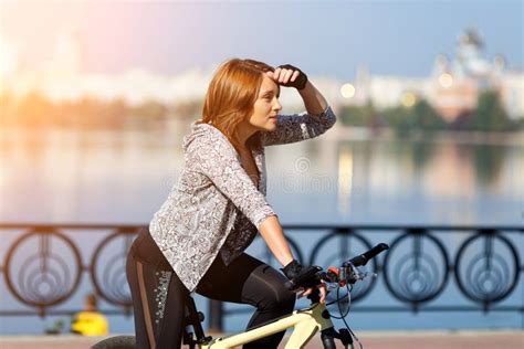 Young Redhead Woman Riding A Bike On Embankment Active People Outdoors