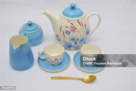 우아하고 전통적인 도자기 파란색과 흰색의 우아한 꽃 도자기 중국 세라믹 차 커피 컵과 찻주전자 및 접시 세트의 모형 디자인 세트와 흰색 배경에 격리된 금숟가락 음료 용기 0