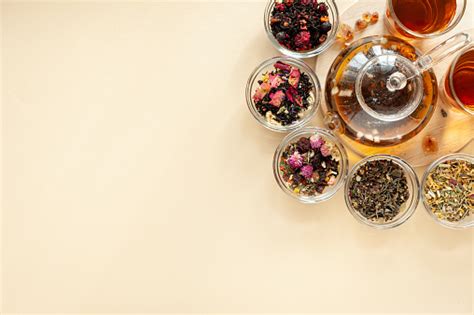 베이지 색 배경에 뜨거운 양조 차로 가득 주전자 옆에 녹색 검은 색 허브 차의 다른 유형의 세트 맛있는 유기농 음료 위에서 볼 수 있습니다 텍스트의 장소입니다 0명에 대한