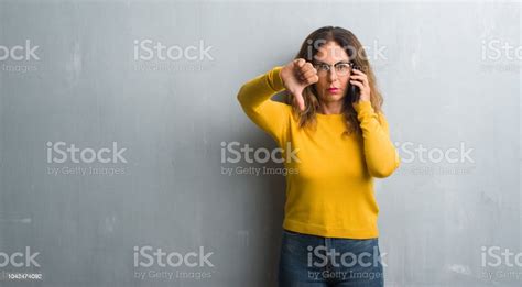 중세 스페인 여자와 성 난 얼굴 아래로 엄지 싫어 보여주는 음수 부호 거부 개념 전화 통화 갈색 머리에 대한 스톡 사진 및 기타 이미지 Istock