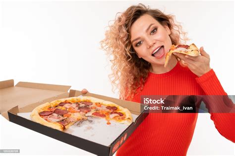 매력적인 곱슬 금발 소녀는 흰색 배경에 그녀의 손에 상자를 들고 피자 의 조각을 시도 곱슬 머리에 대한 스톡 사진 및 기타 이미지 곱슬 머리 금발 머리 담 경계
