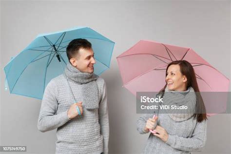 회색 벽 배경 스튜디오 초상화에 고립 된 우산 아래 함께 회색 스웨터 스카프에 커플 여자 사람입니다 건강 한 생활 습관 병 아픈 질병 치료 추운 계절 개념 복사 공간을 모의