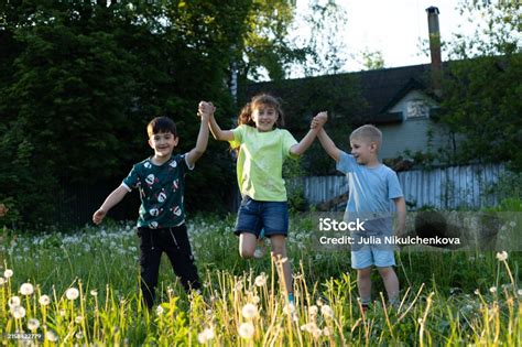 공원에서 행복하고 우정을 나누는 아이들이 자연 속에서 야외에서 함께 놀고 있습니다 행복 다양성 미소를 지으며 서서 손을 잡고 바깥 녹색 정원에서 햇살을 쬐는 아이 친구들