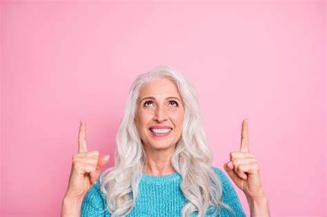 초상화 의 긍정적 인 쾌활한 늙은 여자 포인트 집게 손가락 최대 Copyspace 모양 표시 광고 프로모션 표시 할인 정보 착용 점퍼 파스텔 색상 배경을 통해 고립