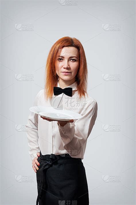 穿着服务员制服的年轻女子拿着盘子