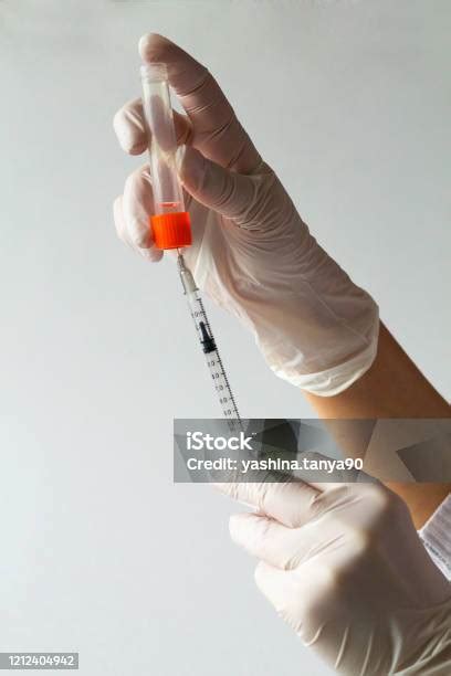 흰색 배경에 고립 손에 주사기 여성 의사는 흰색 배경에 고립 된 그의 손에 주사기를 들고있다 흰색 장갑을 낀 의사는 주사기를