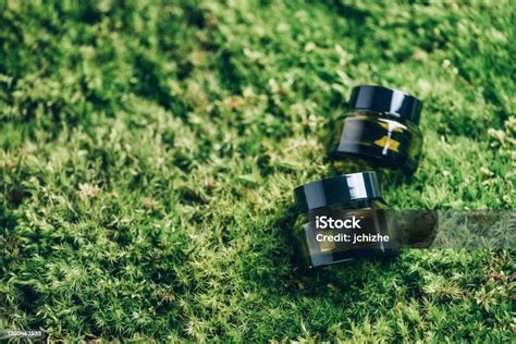 잔디 이끼 배경에 스킨 케어 제품에 대한 녹색 유리 병 용기 스킨 케어 유기농 화장품 바디 트리트먼트 스파 컨셉 비건 친환경 화장품 제품 바이오필리아 디자인 샴푸에 대한