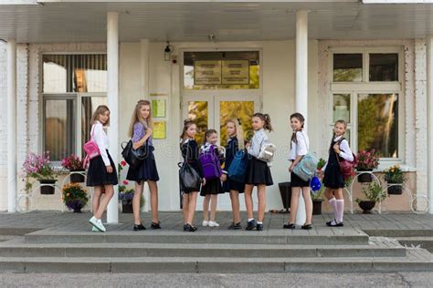 Группа в составе школьницы с рюкзаками идет к школе Стоковое Фото изображение насчитывающей