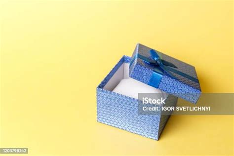 노란색 배경에 파란색 리본 파란색 빈 선물 상자입니다 맨 위 보기 공간을 복사합니다 다채로운 배경 최소한의 크리스마스 새해 창조적 인 개념 트렌디한 파스텔 칼라 0명에 대한