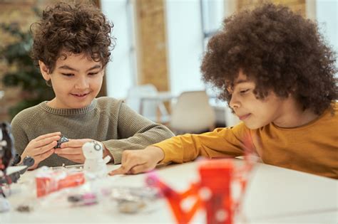 친구와 함께 테이블에 앉아 Stem 수업 중에 로봇의 세부 사항을 조사하는 동안 즐거운 찾고 친절한 어린 소년 4 5세에 대한 스톡 사진 및 기타 이미지 Istock