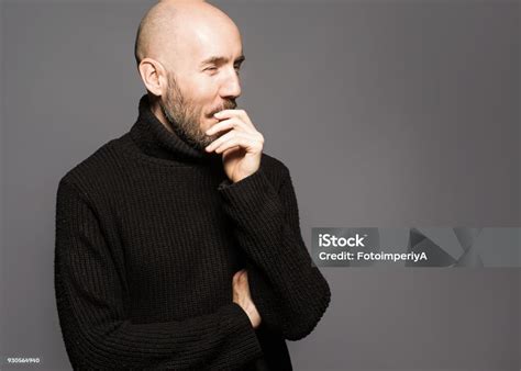 패션 세로 남자는 검은 스웨터에 밝은 회색 배경 위에 서 닫습니다 클래식 스타일입니다 대머리 머리를 면 도입니다 복사공간입니다 스튜디오 촬영 40 49세에 대한 스톡 사진