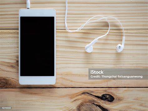 나무 테이블 및 텍스트와 로고 또는 기술 통신 및 엔터테인먼트 개념에서 기호에 대 한 빈 공간에 스마트폰 화이트 헤드폰 0명에