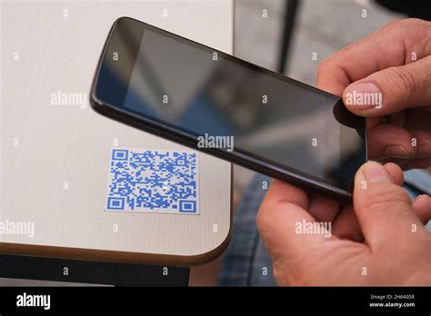 Man Hand Using The Smartphone To Scan The QR Code In A Bar Table Stock Photo Alamy