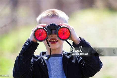 흐린 배경에 거리에서 쌍안경을 통해 의도적으로 무언가를보고 작은 귀여운 귀여운 금발 소년의 초상화 어린이 무죄 꿈 환상과 상상력 개념 개념에 대한 스톡 사진 및 기타 이미지