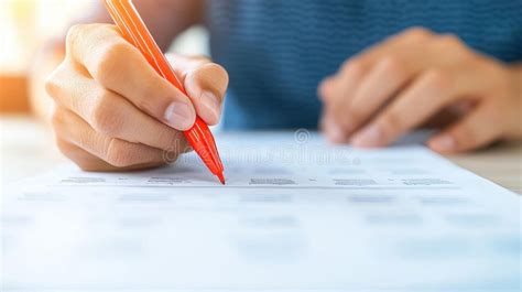 A Closeup View Of A Person Using A Red Marker To Correct Errors On A