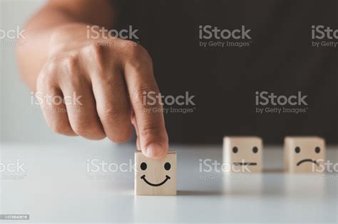 고객 서비스 최고의 우수한 비즈니스 평가 경험 만족도 검토 설문 조사 개념입니다 나무 큐브 블록에 미소 얼굴과 흐릿한 슬픈 얼굴 아이콘을 선택하는 고객의 손을 클로즈업합니다