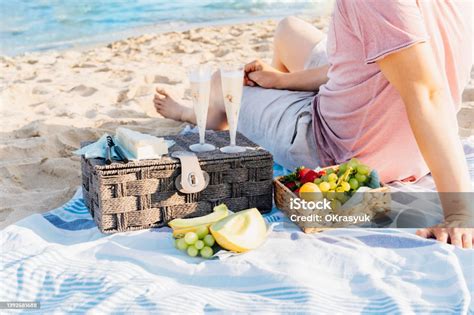 일몰에 여름 해변 피크닉 담요에 앉아 신선한 제철 과일 치즈 및 스파클링 와인 한 잔과 함께 해변에서 주말 피크닉을 즐기고 있습니다 두 사람을위한 낭만적 인 데이트 25
