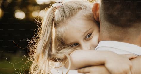 귀여운 작은 소녀가 야외에서 일몰을 배경으로 슈퍼히어로 아버지를 껴안고 시선을 돌리고 있다 사진 Unsplash의 사진술 이미지