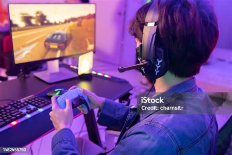 네온 게임룸에서 게임 컨트롤러로 드라이빙 게임을 하는 게이머 비디오 게임에 대한 스톡 사진 및 기타 이미지 비디오 게임