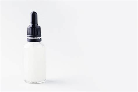 세럼 프라이머 또는 히알루론산 또는 콜라겐 모이스처라이저를 회색 배경에 드롭퍼가 있는 화장품 병에 보관하십시오 여성 얼굴 스킨 케어 제품입니다 스킨 케어 컨셉 복사 공간 0