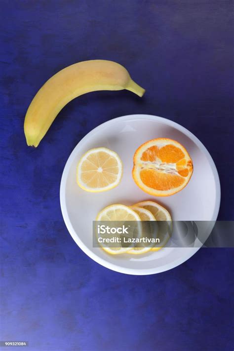 미니 스타일 레몬 및 진한 파란색 배경 건강 한 음식 채식 팝 아트에 흰색 접시 노란 바나나에 절반 오렌지의 조각에서 자외선 배경에 감귤 류 0명에 대한 스톡 사진 및 기타