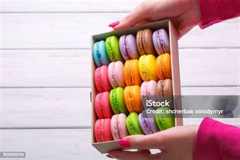 흰색 나무 배경 배경 상단 보기에 맛 있는 마카롱 선물 상자를 들고 손 손에 대한 스톡 사진 및 기타 이미지 손 하이 앵글 다중 색상 Istock