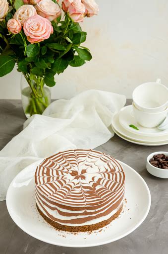 구운 얼룩말 대리석 치즈 케이크는 바닐라와 초콜릿 레이어를 콘크리트 배경에 흰색 접시에 얹지 않습니다 수직 방향 공간을 복사합니다 얼룩말에 대한 스톡 사진 및 기타 이미지