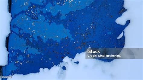 녹슨 금속 표면의 추상적 인 파란색 그런 지 질감은 깊은 파란색으로 칠하고 프레임에 의해 흰색 눈으로 덮여 있습니다 녹은 눈에서 젖은 오래된 금속 판에 페인트를 박리 겨울