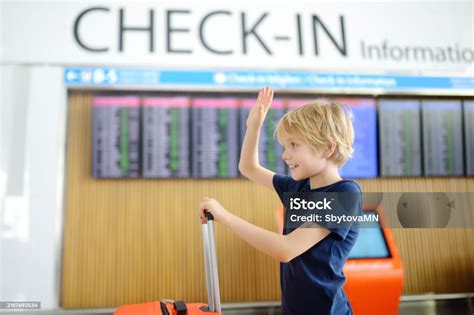 국제 공항 또는 시간표의 정보 표시 근처의 기차역 플랫폼에 있는 귀여운 십대 초반 소년의 초상화 체크인 여행 관광 아이들과