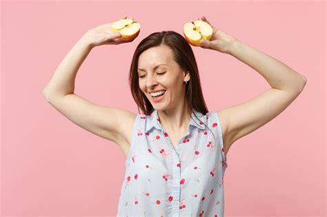 여름 옷에 웃는 젊은 여자 핑크 파스텔 배경에 고립 된 신선한 잘 익은 사과 과일의 Halfs 지주를 유지 사람들은 생생한 라이프 스타일 휴식 휴가 개념입니다 복사 공간을