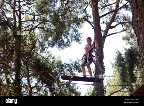 Girl Teenager With Frightened Face With Climbing Equipment In The Rope