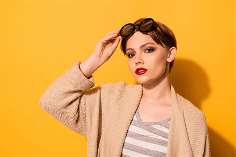 유행 선글라스와 밝은 노란색 배경에 캐주얼 옷에 모델의 세련 된 보세요 그녀는 심각한 이며 보이는 안경 들고 사람 얼굴에 대한 스톡 사진 및 기타 이미지 Istock