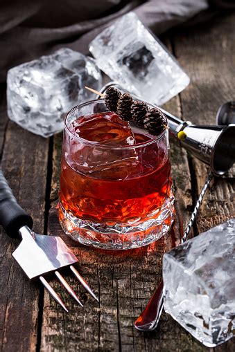 나무 테이블과 얼음 위에 서있는 유리에 꼬치에 얼음과 작은 원뿔이있는 칵테일 포크 측정 유리 및 배경에 천 가문비나무에 대한 스톡 사진 및 기타 이미지 Istock