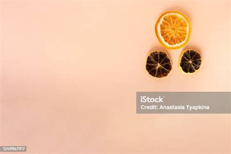 오렌지와 갈색 붉은 색의 오렌지의 세 가지 건조 슬라이스와 플랫 평신도 구성 과일 조각은 오른쪽 상단 모서리에 있습니다 종이 질감이 있는 밝은 분홍색 배경의 오브젝트입니다