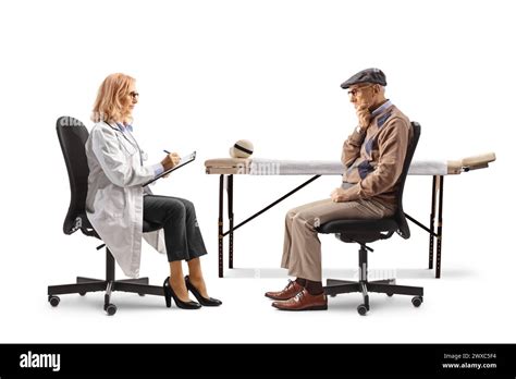 Pensive Mature Patient And A Female Doctor Sitting In A Chair And Writing A Document Isolated On