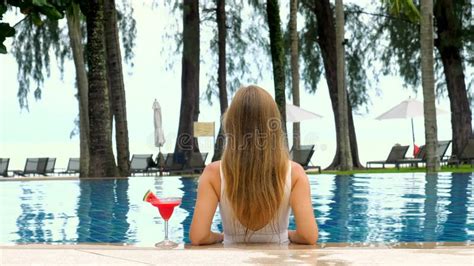 Back View Of Woman Model Lounging In Blue Swimming Pool Stock Footage