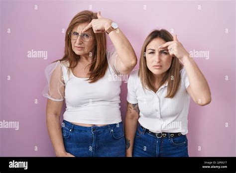 Hispanic Mother And Daughter Wearing Casual White T Shirt Over Pink