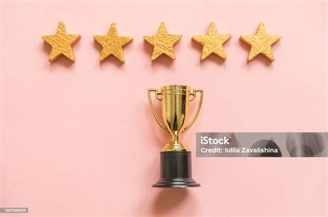 단순히 플랫 레이 디자인 우승자 또는 챔피언 골드 트로피 컵과 핑크 파스텔 배경에 고립 된 5 별 등급 승리의 1 위 경쟁 승리 또는 성공 개념 상단 보기 복사 공간 1위에