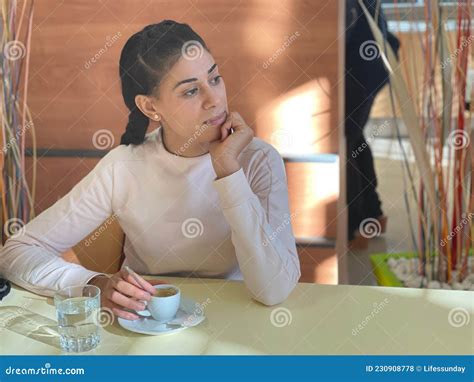 красивая молодая женщина пьёт кофе в кафетерии Стоковое Фото изображение насчитывающей