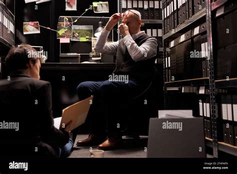 Tired Private Detectives Trying To Solve Criminal Case Working Late At