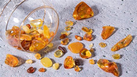 회색 석고 배경에 흩어져 다양한 크기와 모양의 빛나는 노란색과 주황색 발트 황색 돌 0명에 대한 스톡 사진 및 기타 이미지 0명 고대의 광물질 Istock